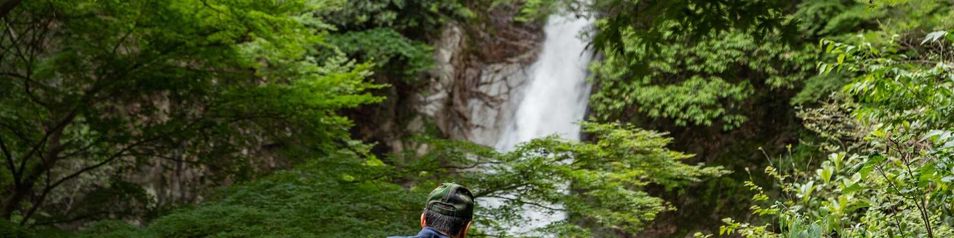 Nunobiki Falls showing a waterfall as well as an individual male