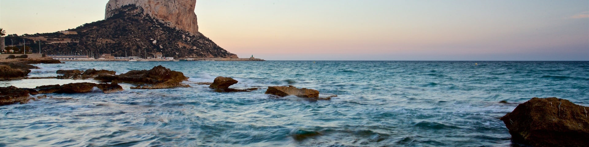 Banos de la Reina Archaelogical Site which includes a sunset, general coastal views and rocky coastline