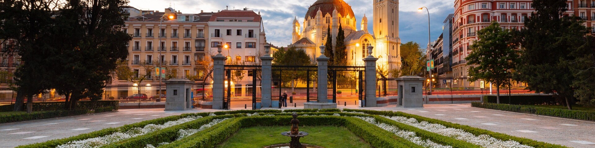 Church of San Manuel y San Benito which includes a park, a sunset and flowers