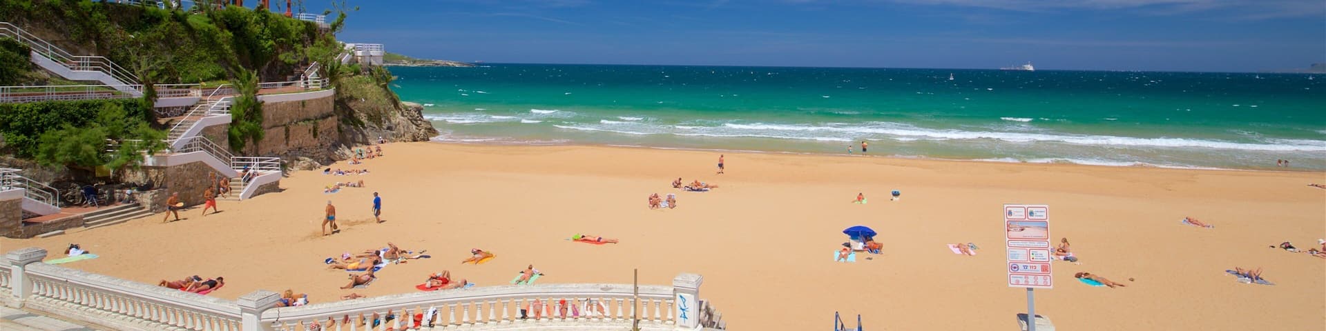 Jardines de Piquio showing a beach and general coastal views as well as a small group of people