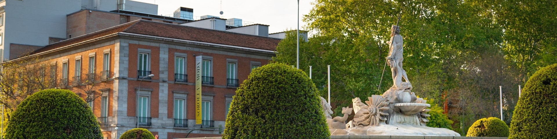 Fountain of Neptune featuring a garden and a statue or sculpture