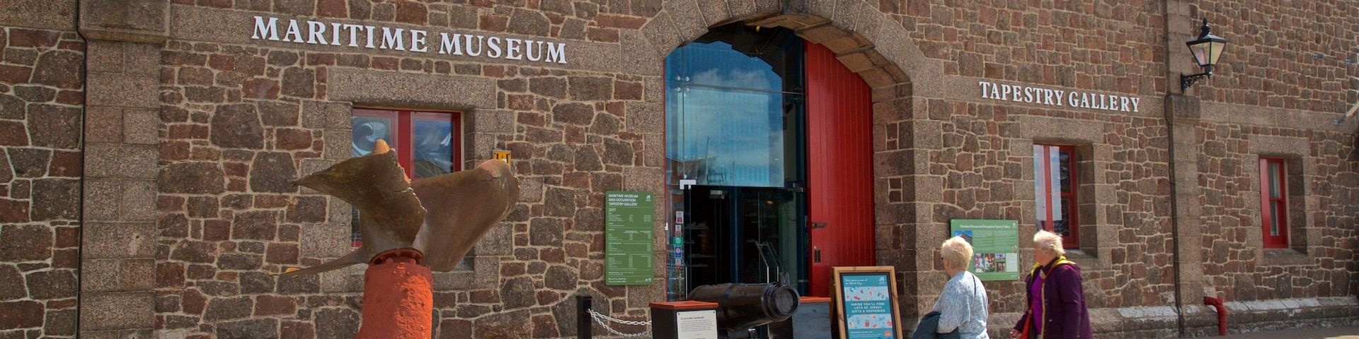Museu Marítimo e Galeria de Tapeçarias com um grande leme e uma estátua de uma figura num casaco vermelho.