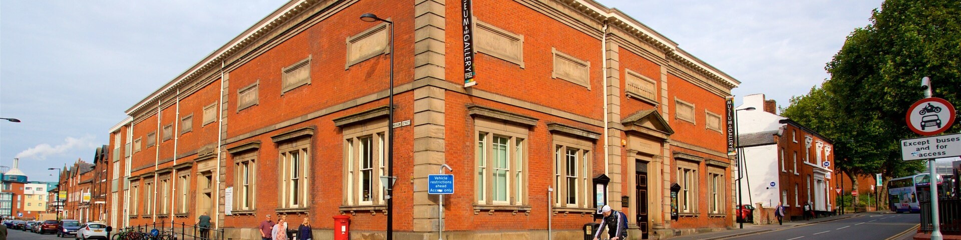 Um edifício de tijolos vermelhos com uma placa indicando o Museu & Galeria.