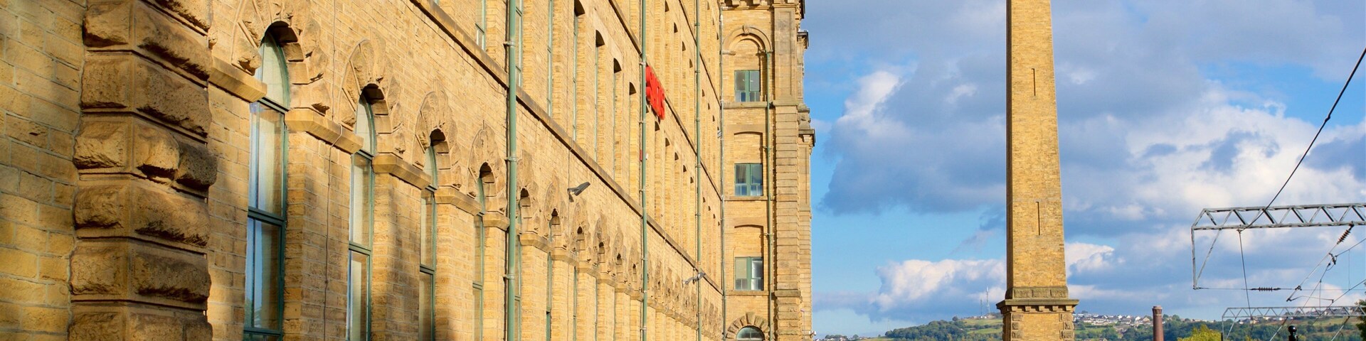 Um edifício histórico com uma torre alta e um estacionamento cheio de carros.