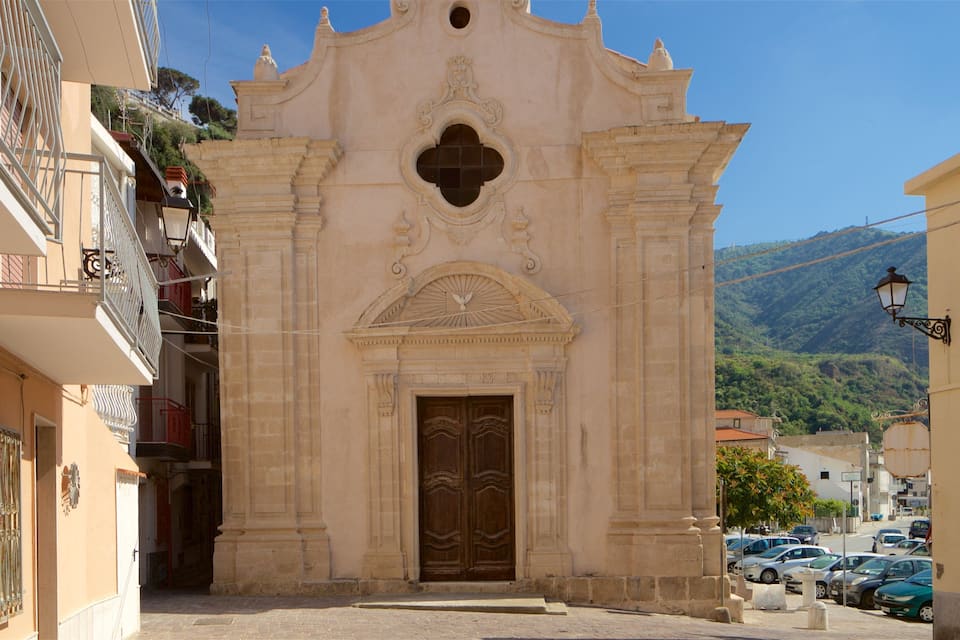 Uma igreja histórica com arquitetura elaborada, uma entrada imponente e um cenário montanhoso.