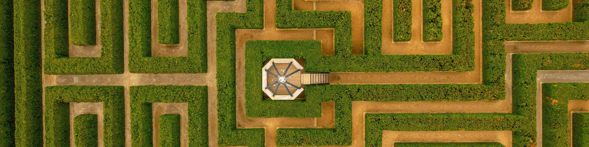 Vista aérea de um jardim labirinto com uma fonte central.