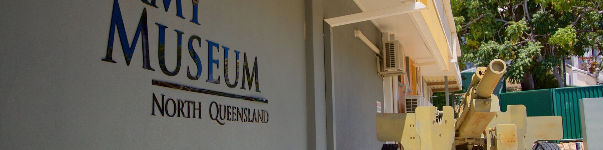 Exterior do Museu do Exército no Norte de Queensland, com um canhão montado e uma placa com o nome do museu.