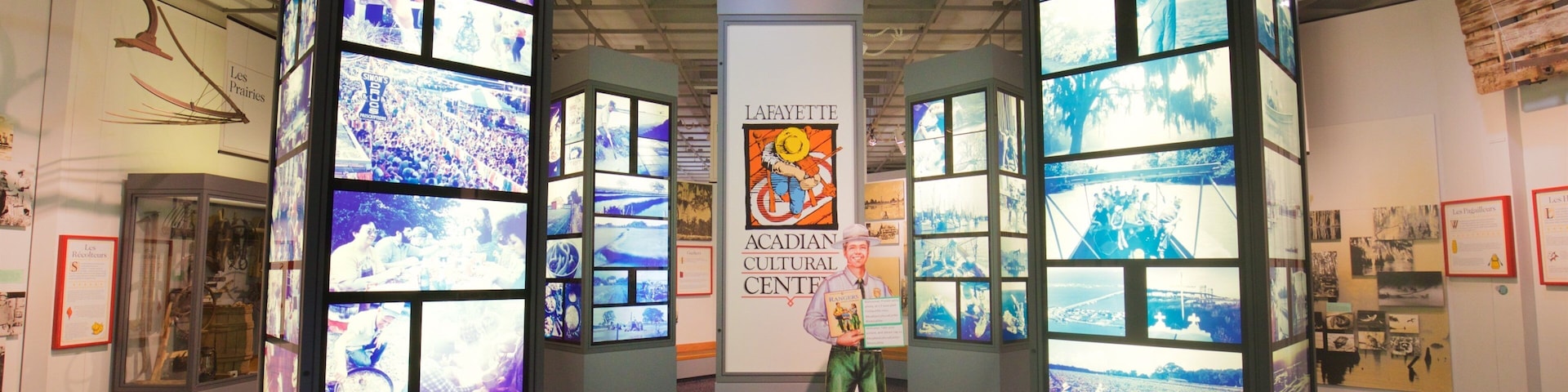 Exposição de museu com grandes painéis e um cartaz central.