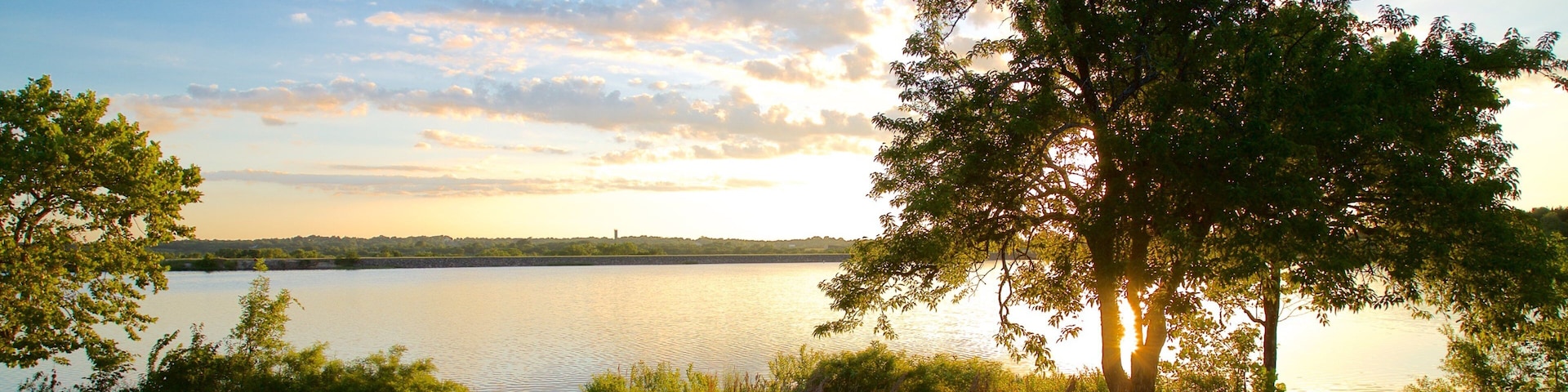 Um lago rodeado por árvores e céu claro.