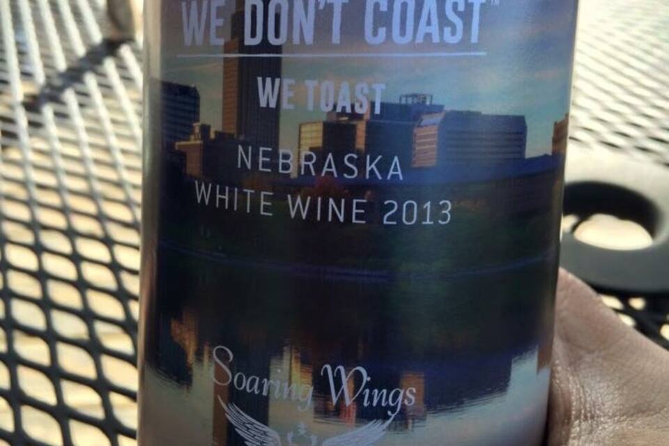 Uma garrafa de vinho branco Omaha We Don't Coast com rótulo mostrando a paisagem urbana.