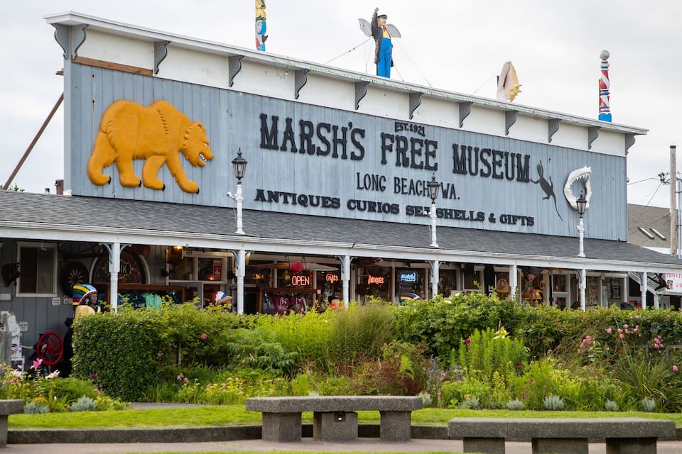 Um edifício com uma grande escultura de urso e uma placa que diz "Marsh's Free Museum".