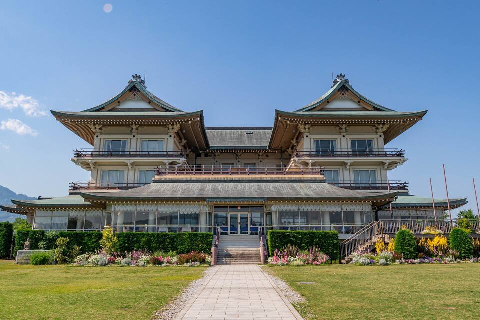 Um edifício japonês tradicional com design simétrico, apresentando duas torres principais e uma entrada central.