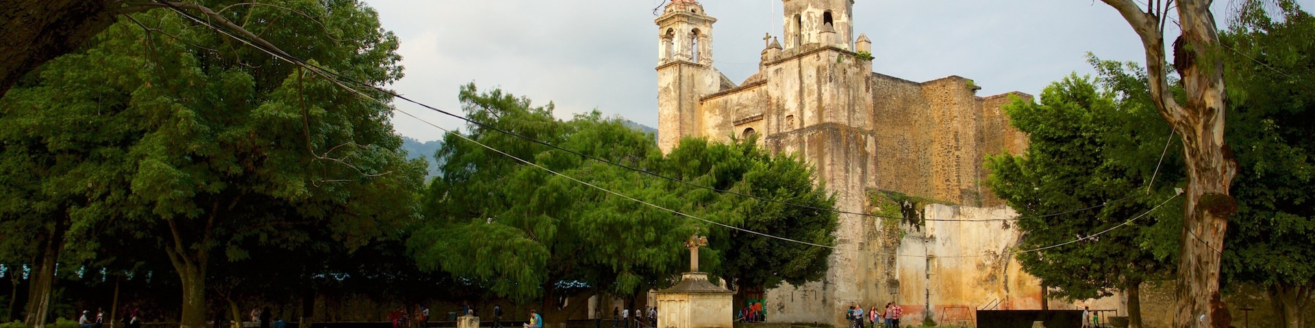 Tepoztlan caracterizando arquitetura de patrimônio e um jardim assim como um pequeno grupo de pessoas