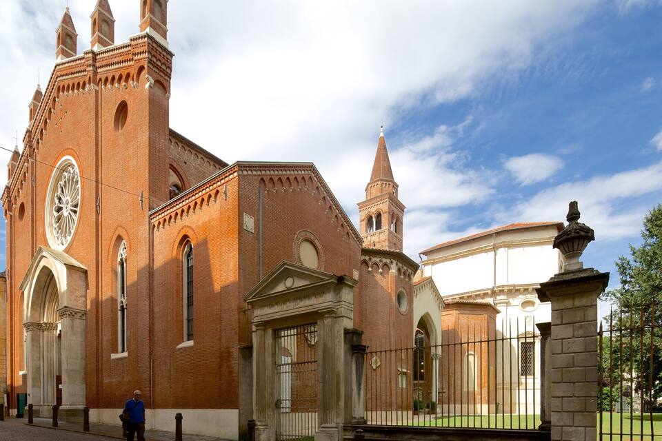 Uma igreja histórica com uma torre do relógio imponente e janelas em arco.