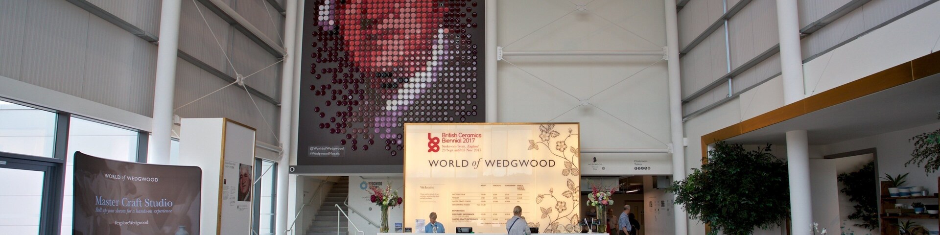 Amplo espaço de exposição interior com destaque para um retrato em mosaico.