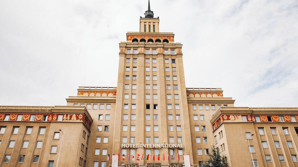 Um edifício grande e bege com a placa "HOTEL INTERNATIONAL" no topo.
