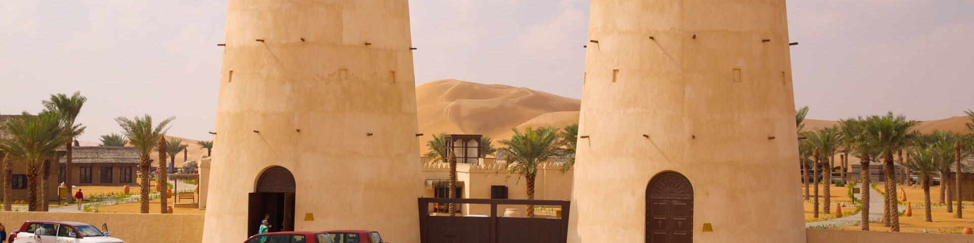 Emirado de Abu Dhabi que inclui paisagens do deserto, uma cidade pequena ou vila e passeio em veículo