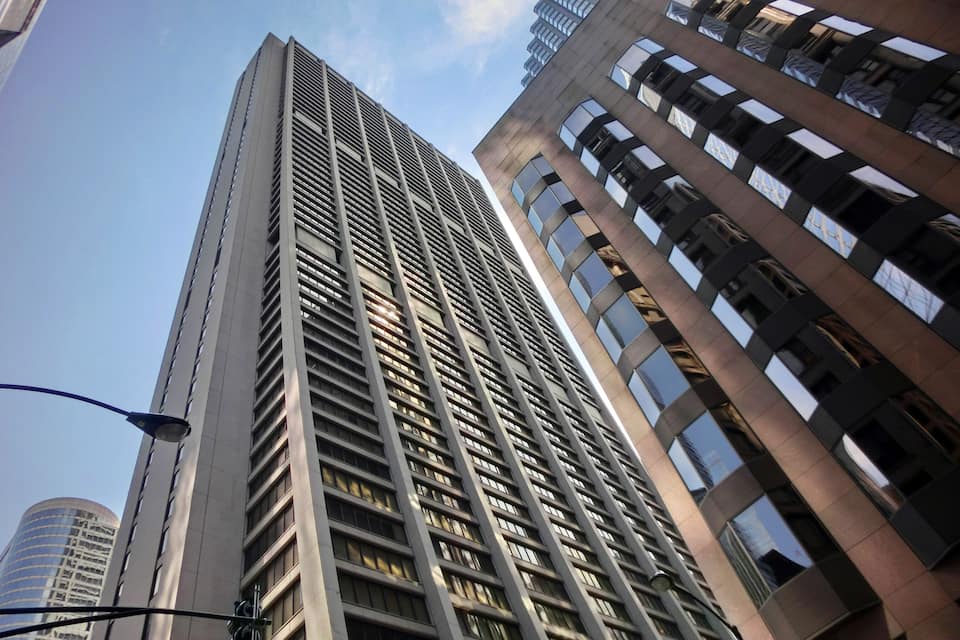 Um edifício alto e moderno com uma fachada curva e uma grade de janelas.