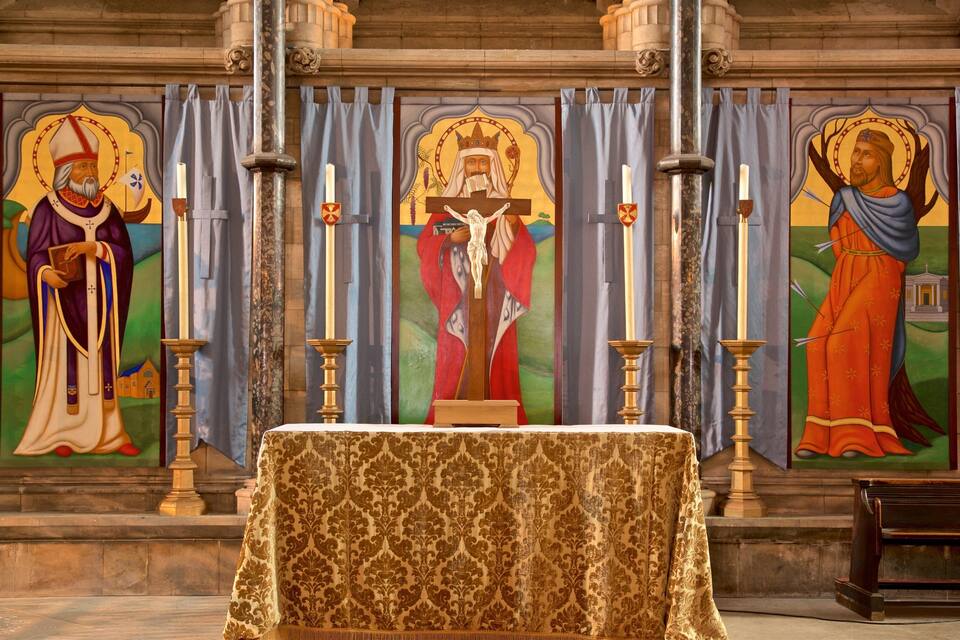 Interior de igreja com pinturas religiosas, altar de madeira e velas.