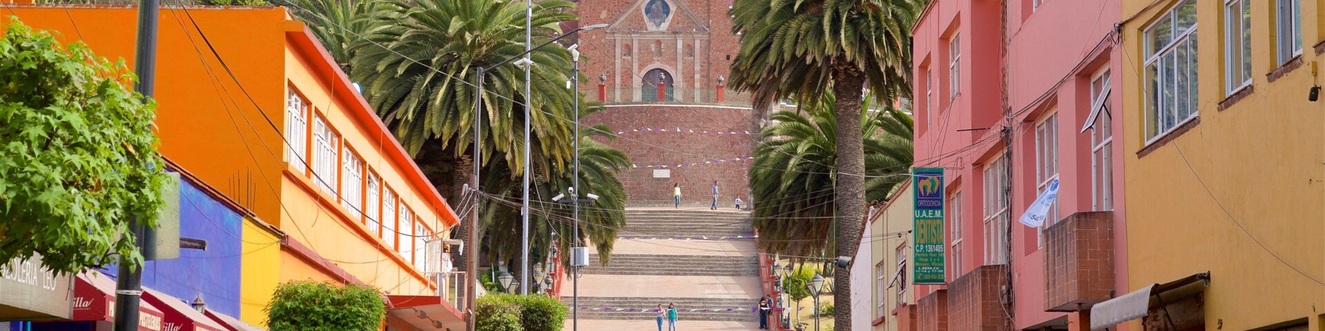 Uma rua que leva a uma igreja com um campanário.