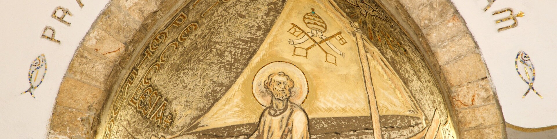 Mosaico de um santo em um barco com uma cruz, cercado por padrões e inscrições ornamentais.