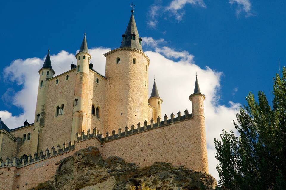 Um castelo com várias torres e uma muralha de pedra.