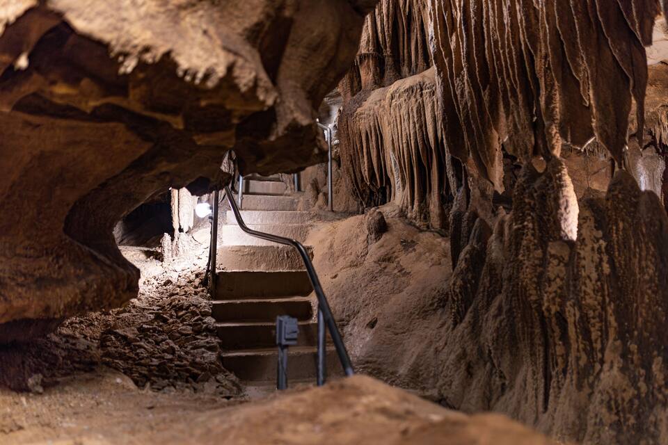 Caverna com estalactites e uma escadaria.