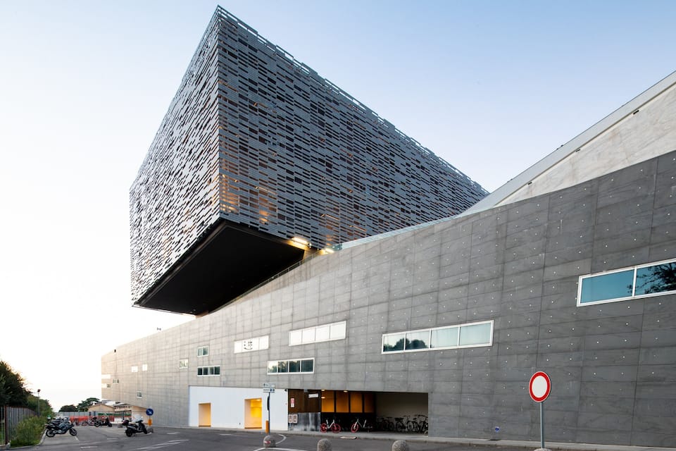 Um edifício moderno com um design angular único e uma grande saliência.