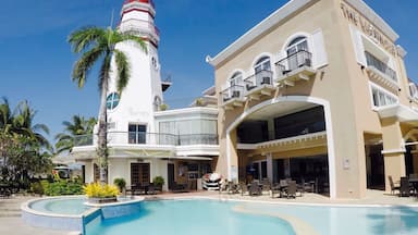 Um resort com piscina, farol e um edifício com varandas.
