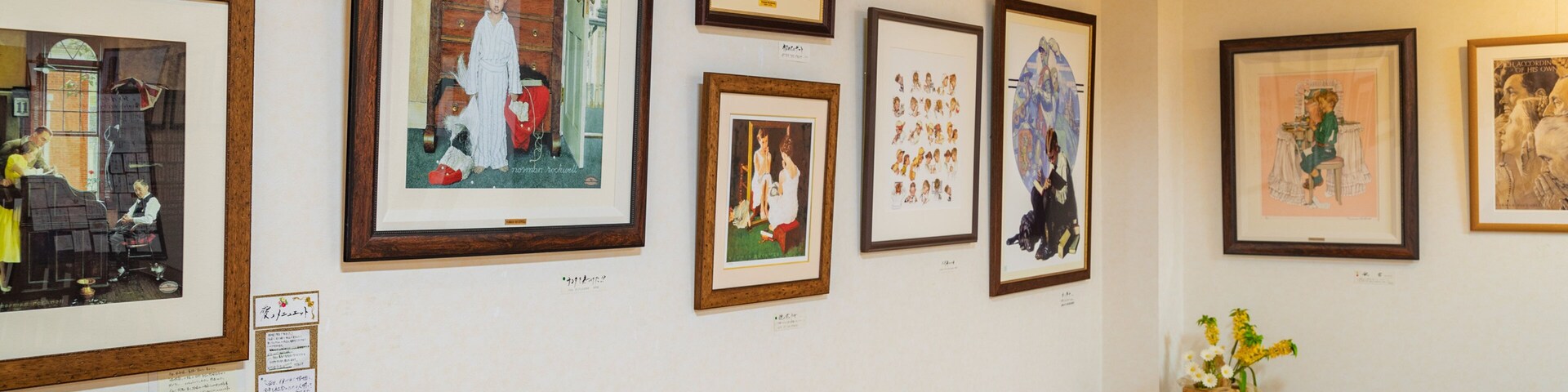 Uma galeria de painel com diversas obras de arte emolduradas.
