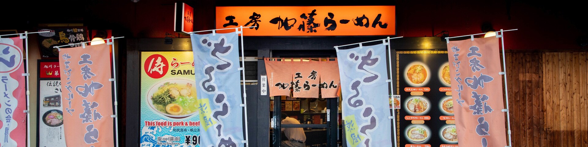 Restaurante com sinalização japonesa e diversos banners com temas gastronômicos.