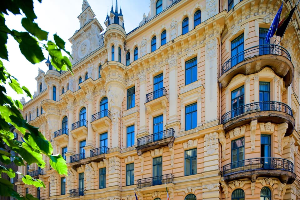 Um edifício histórico com arquitetura elaborada, várias varandas e bandeiras.