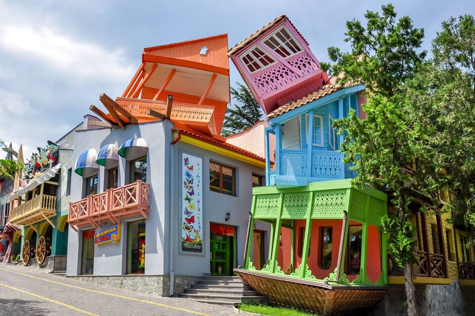 Edifícios coloridos com arquitetura singular, incluindo uma casa com telhado em formato de barco.