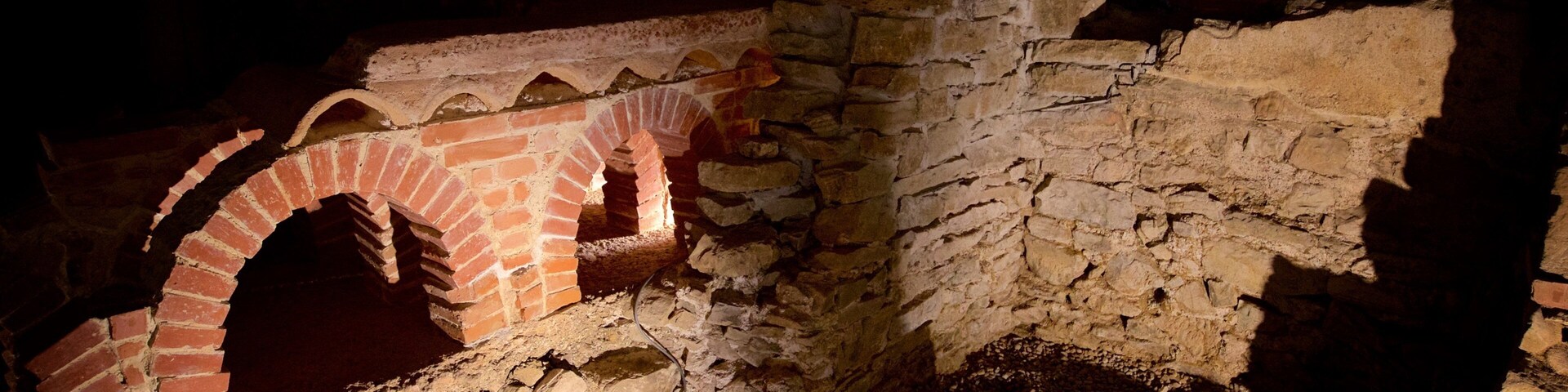 Termas Romanas de Campo Valdés que inclui cenas noturnas e ruínas de edifício