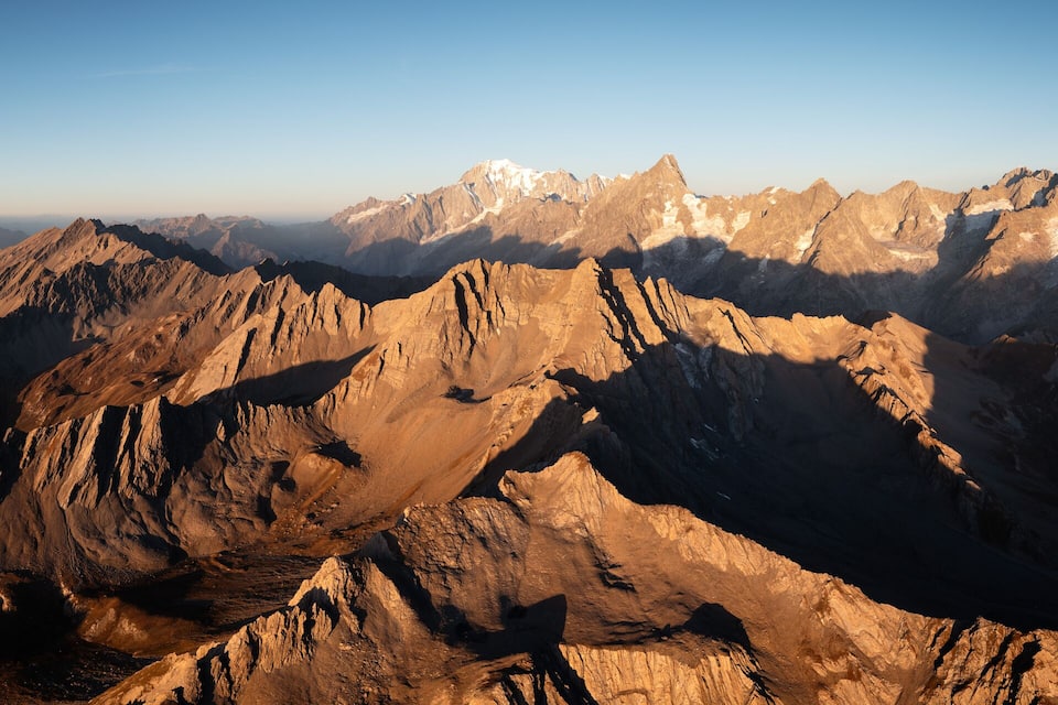 Uma cordilheira acidentada com picos afiados e vales profundos.