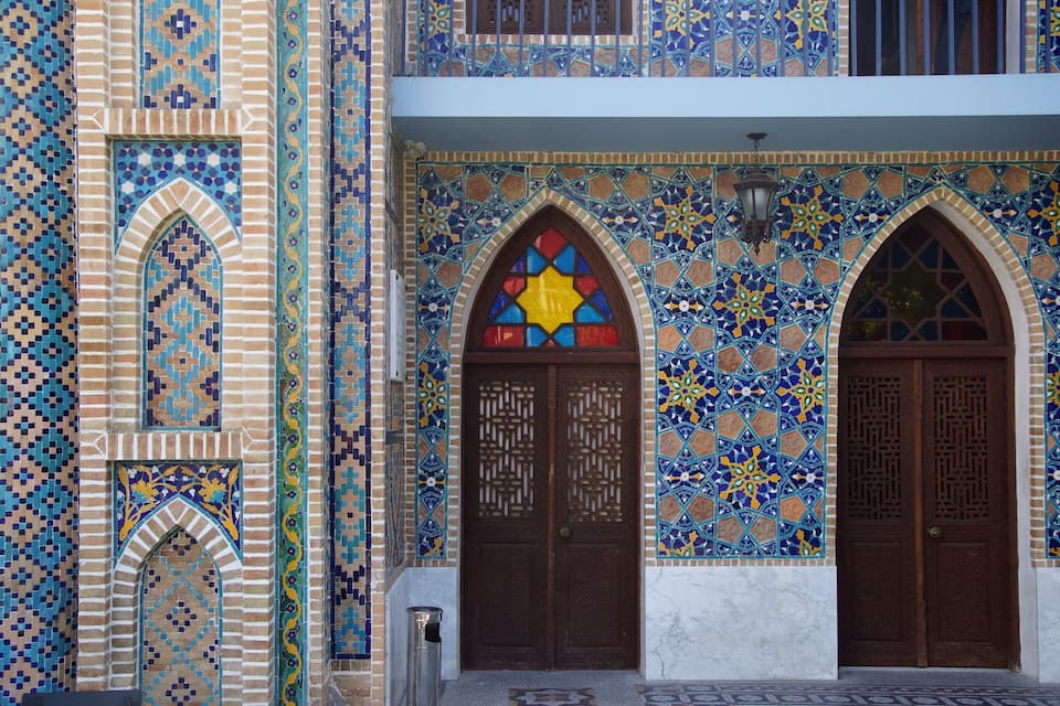 Um edifício com intrincados mosaicos e portas de madeira.