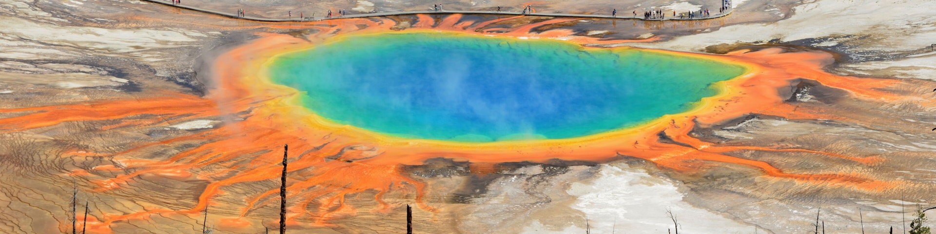 Uma piscina geotérmica vibrante com uma paisagem árida ao redor.