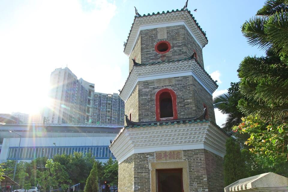 Um edifício tradicional chinês com telhado telhado e uma janela circular vermelha.