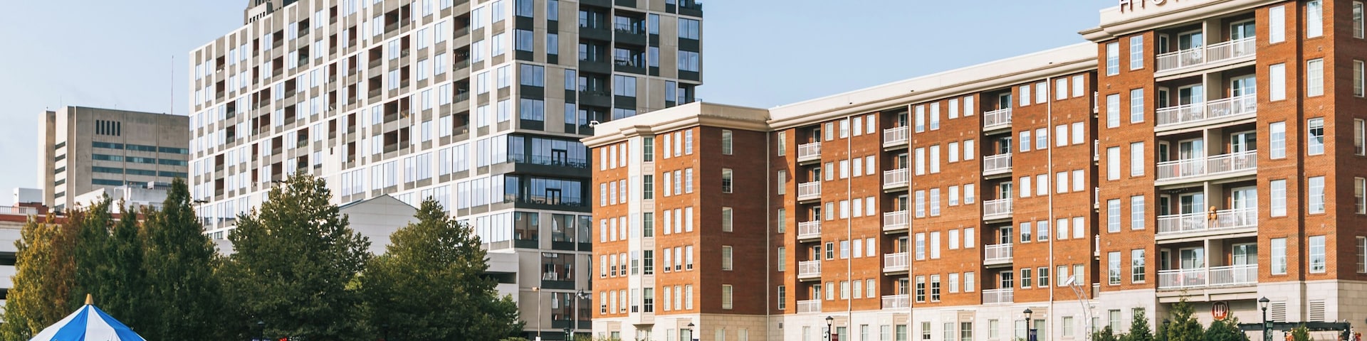 Um edifício de apartamentos moderno com uma placa indicando 'HIGHPOINT' e um carrossel em primeiro plano.