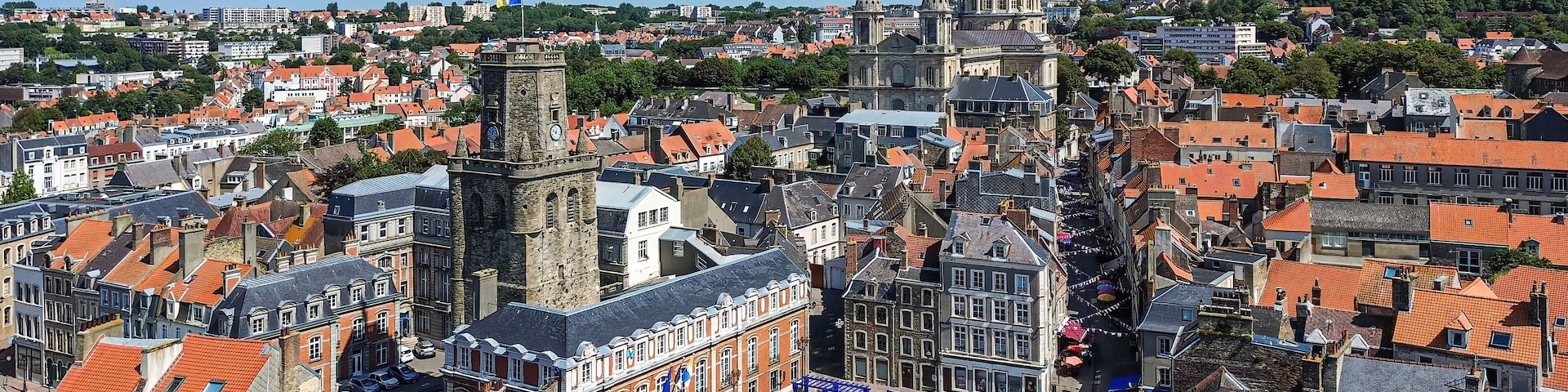 Uma cidade histórica com uma igreja importante, uma torre e uma praça pública bem conservada.