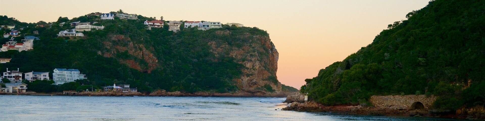 Paisagem costeira com um penhasco e edifícios no topo.