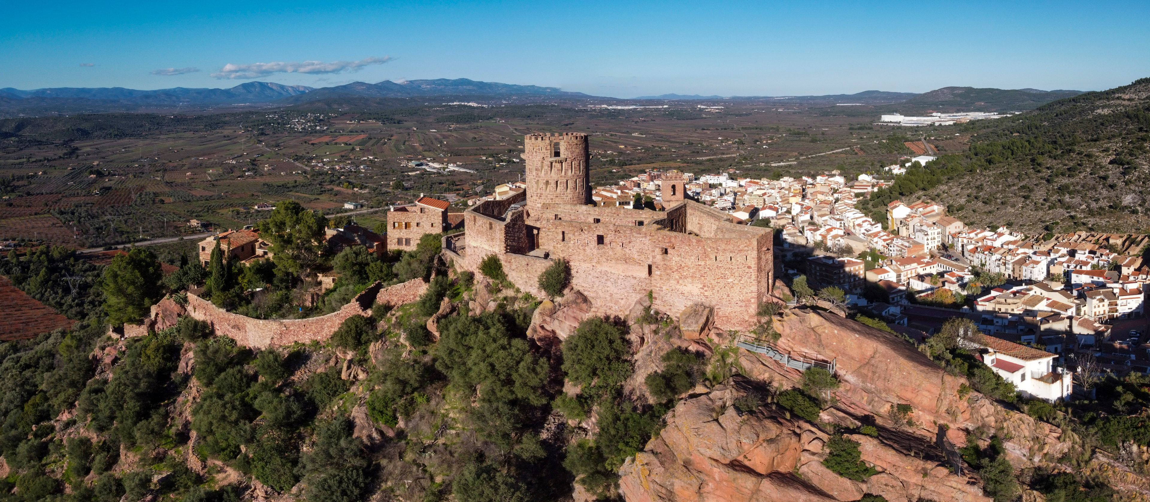 Um castelo histórico no topo de uma colina com vista para uma cidade.
