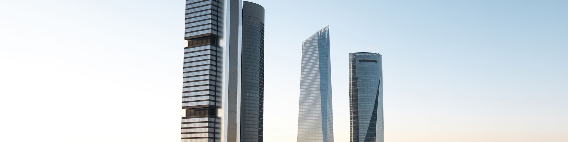 Paisagem urbana com arranha-céus modernos, uma combinação de edifícios residenciais e comerciais, e céu claro.