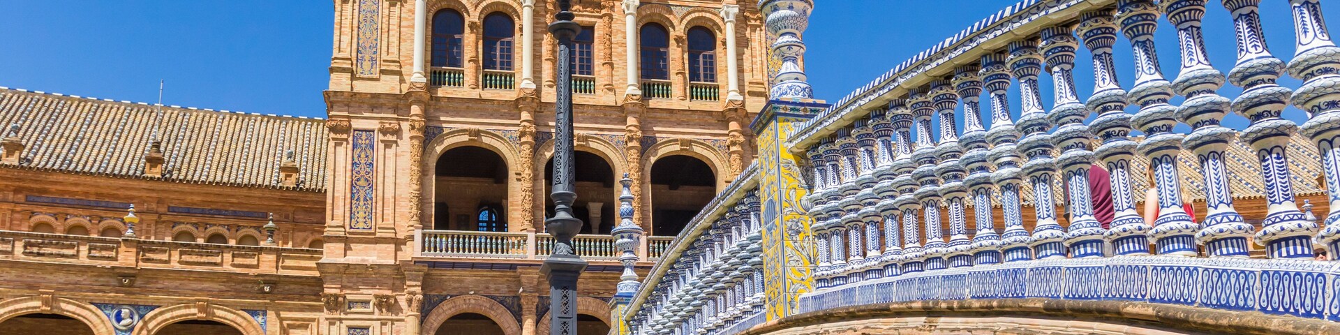 Um edifício histórico com arquitetura elaborada e uma ponte colorida com trabalhos em azulejos detalhados.