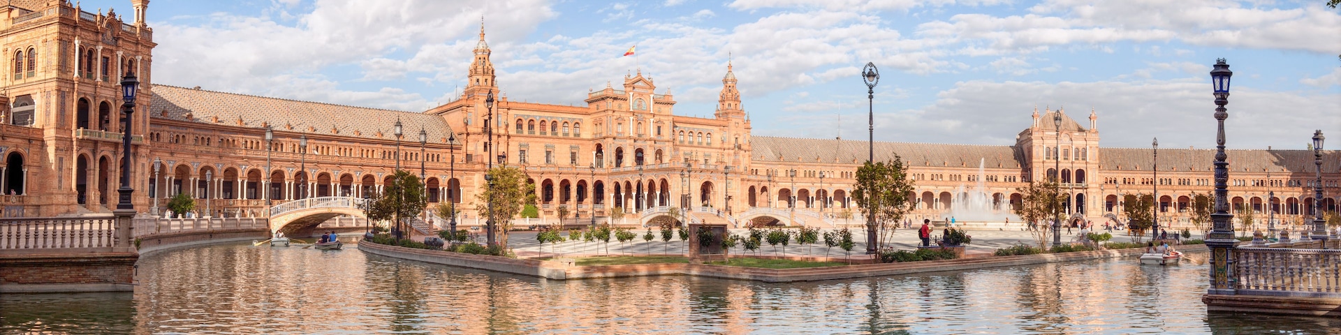 Um edifício histórico com um amplo pátio e um canal.