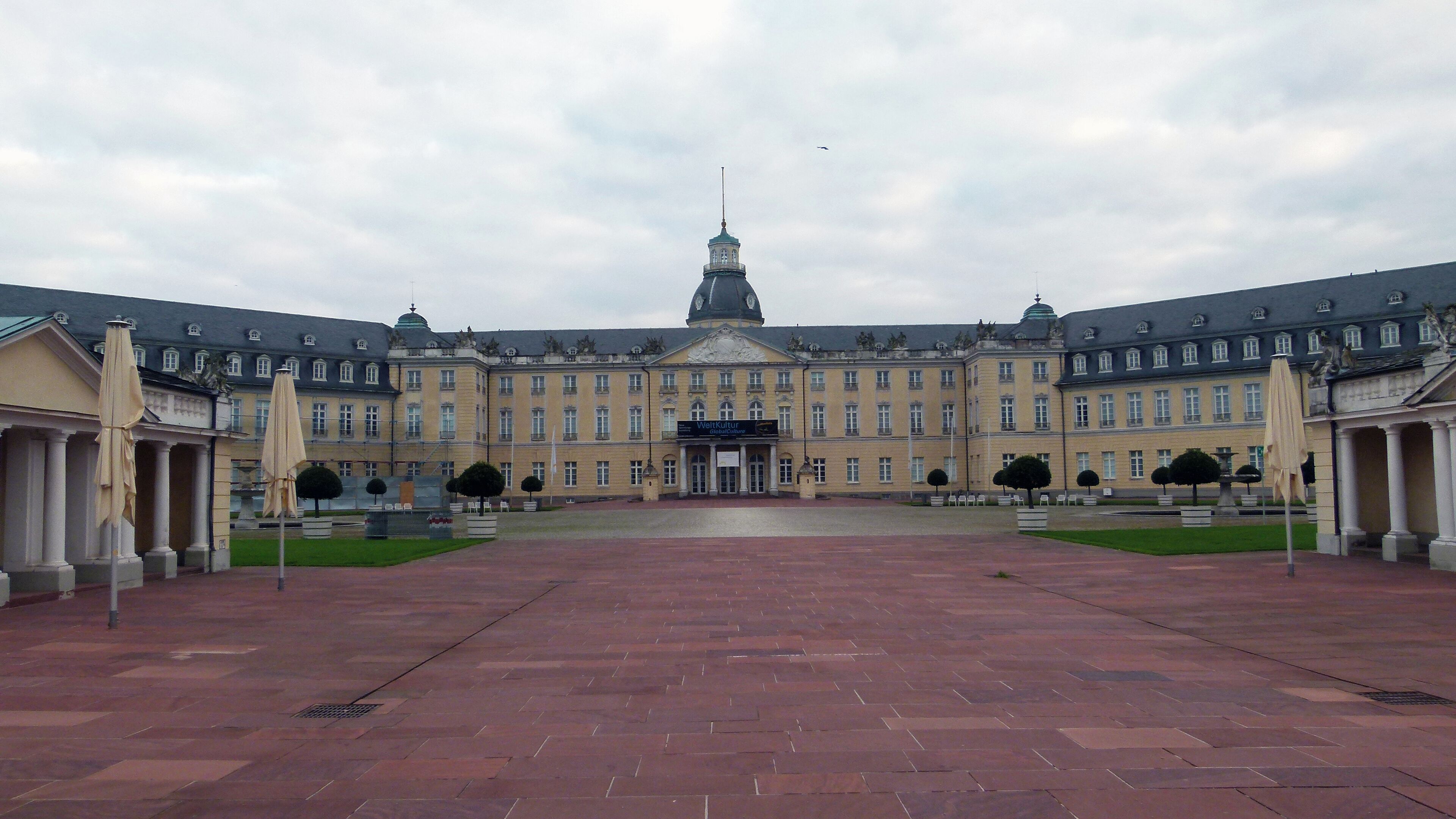 Um edifício grande e histórico com uma cúpula central e alas simétricas.