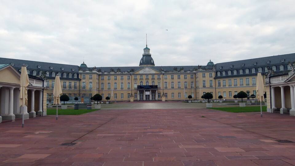 Um edifício grande e histórico com uma cúpula central e alas simétricas.