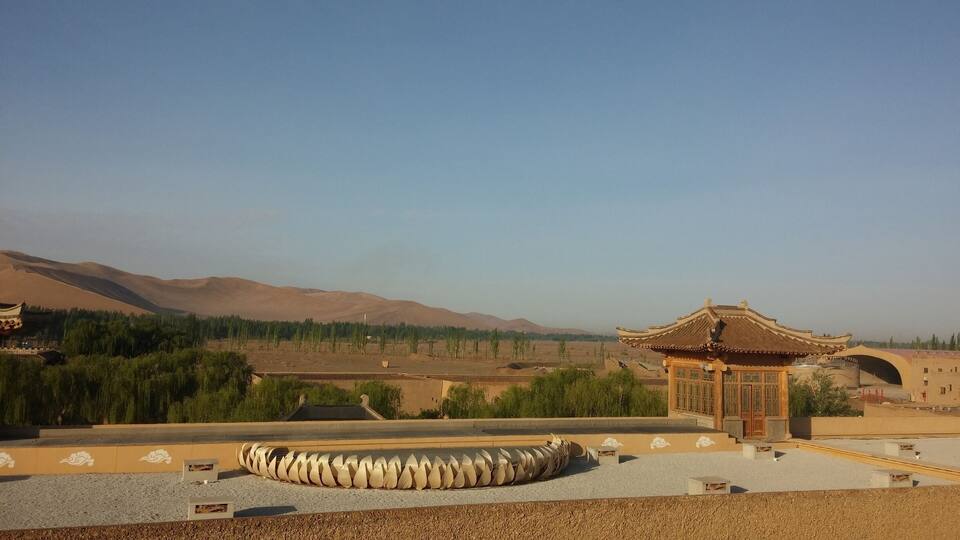 A rooftop view of the sand dunes and Gobi Desert in the distance.