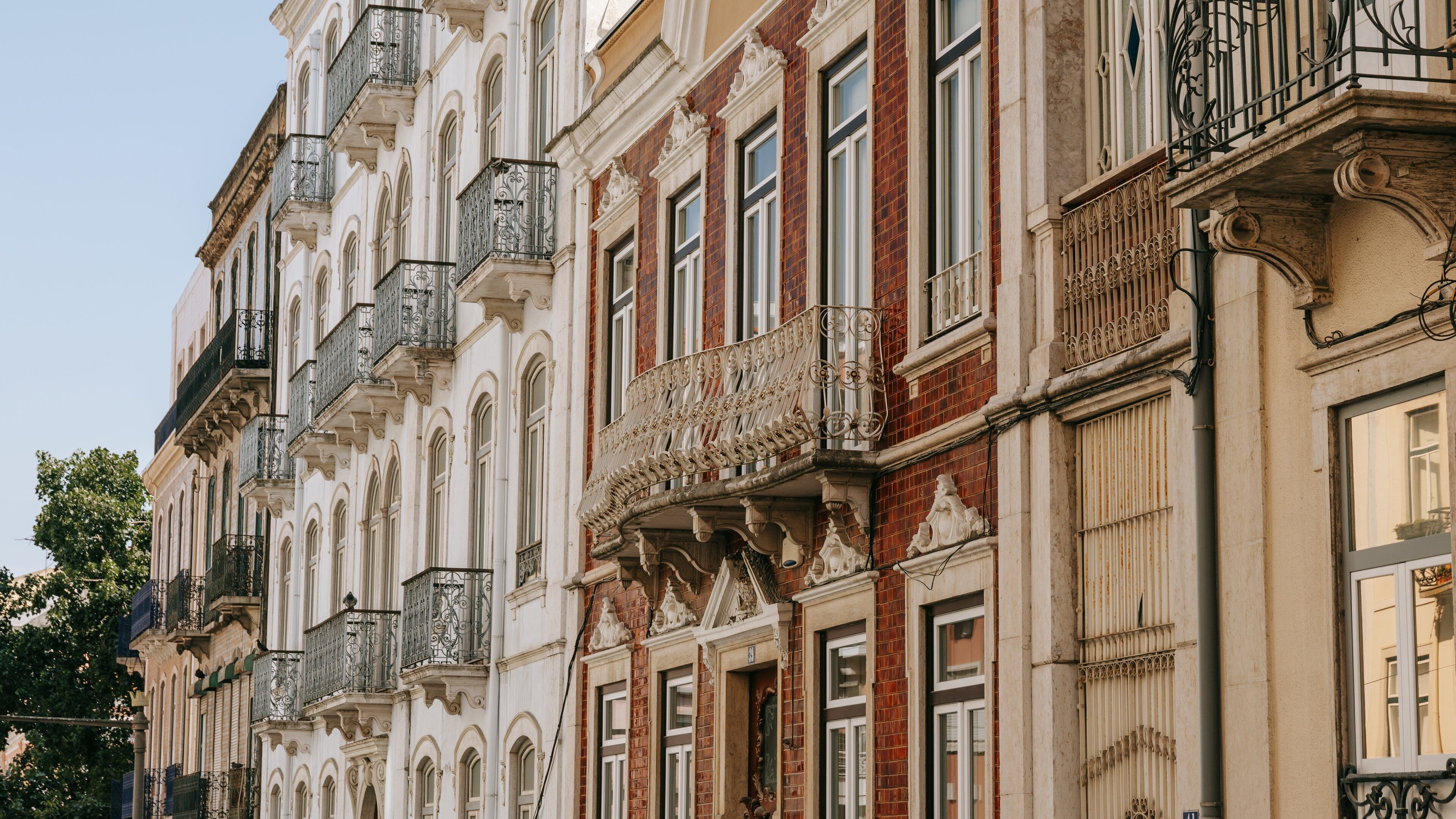 Uma fileira de edifícios históricos com varandas elaboradas e fachadas detalhadas.