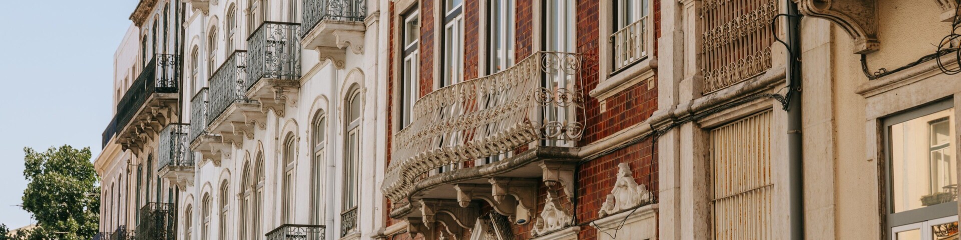 Uma fileira de edifícios históricos com varandas elaboradas e fachadas detalhadas.